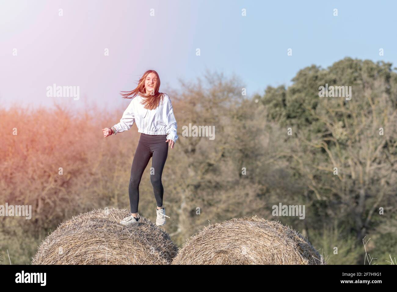 latina teenage girl in black leggings, top and jacket posing on straw ...