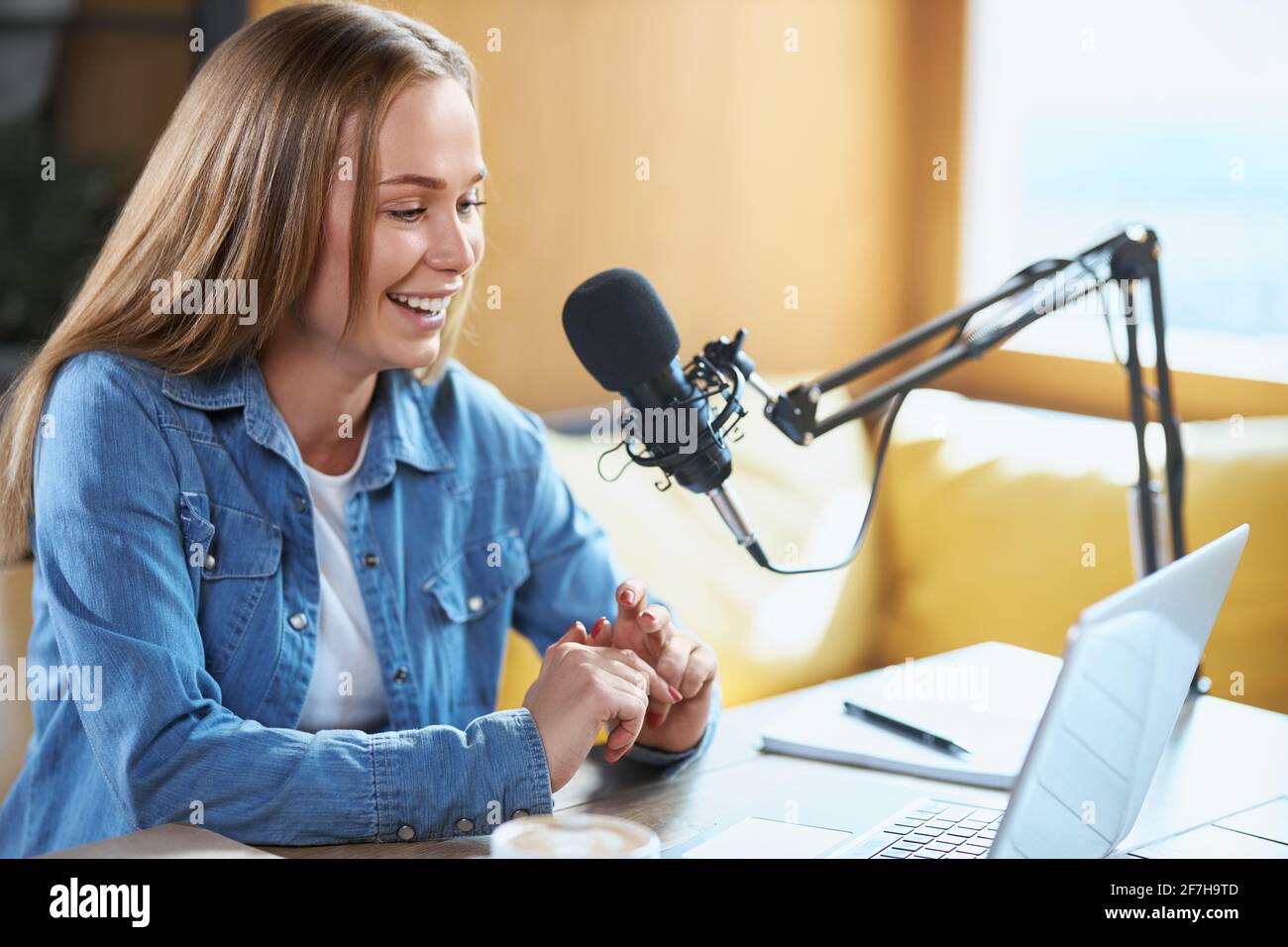 Side view of smiling young beautiful blogger woman in denim jacket ...