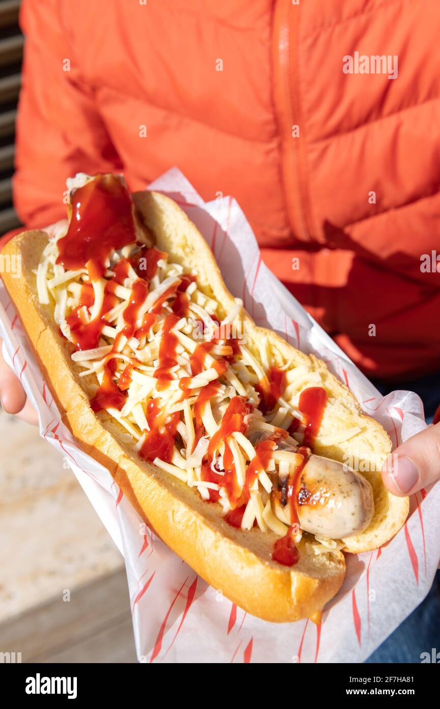 Girl is holding take away Cheese Hot Dog Stock Photo - Alamy