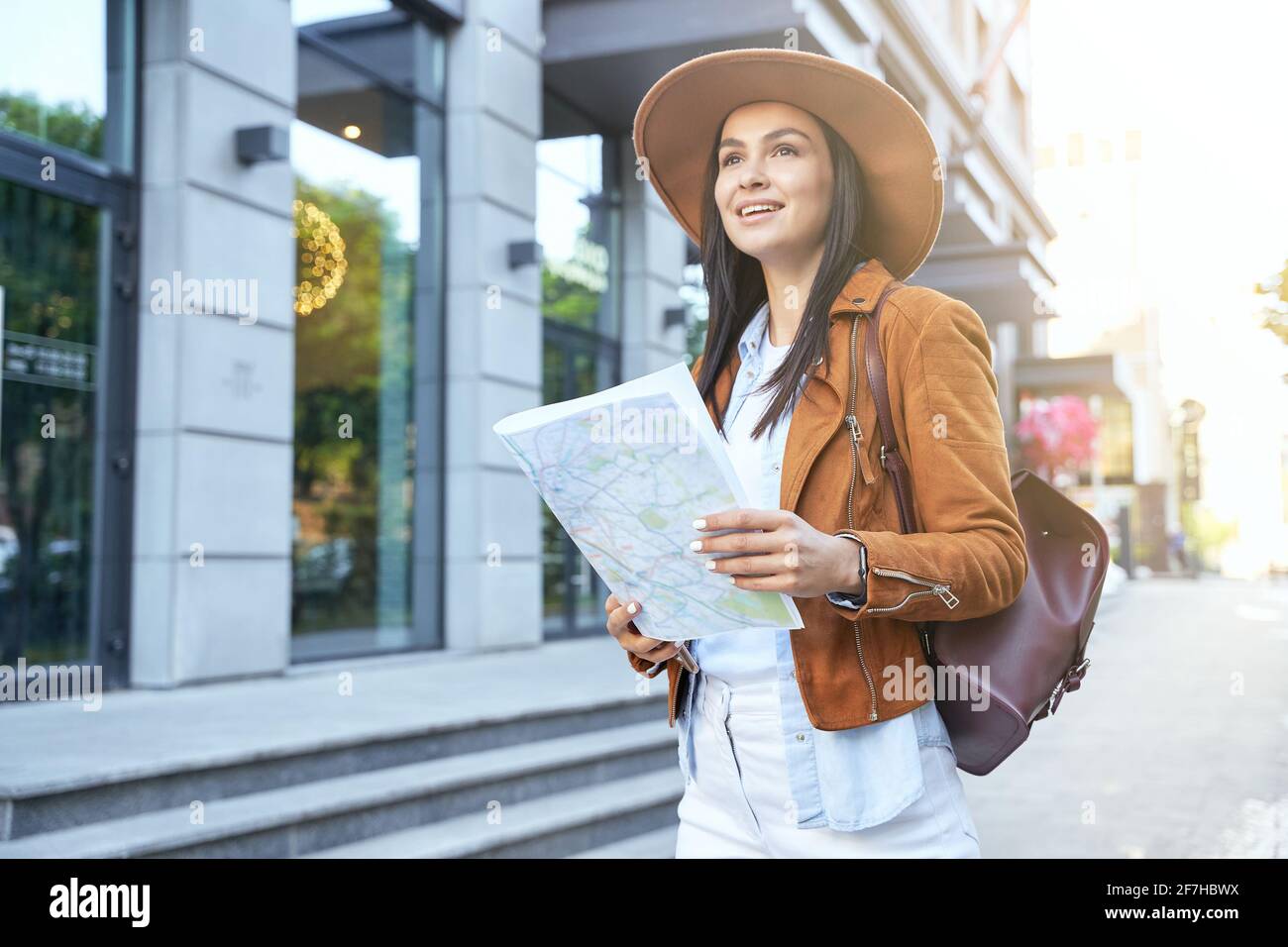 Young lady in hat using map while walking outdoor Stock Photo - Alamy
