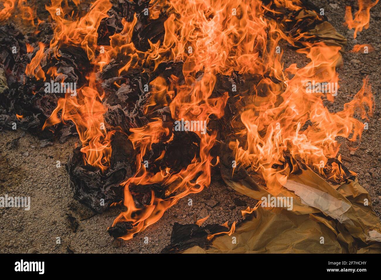 Burning a fire out of paper in an open space. Burning paper waste in ...
