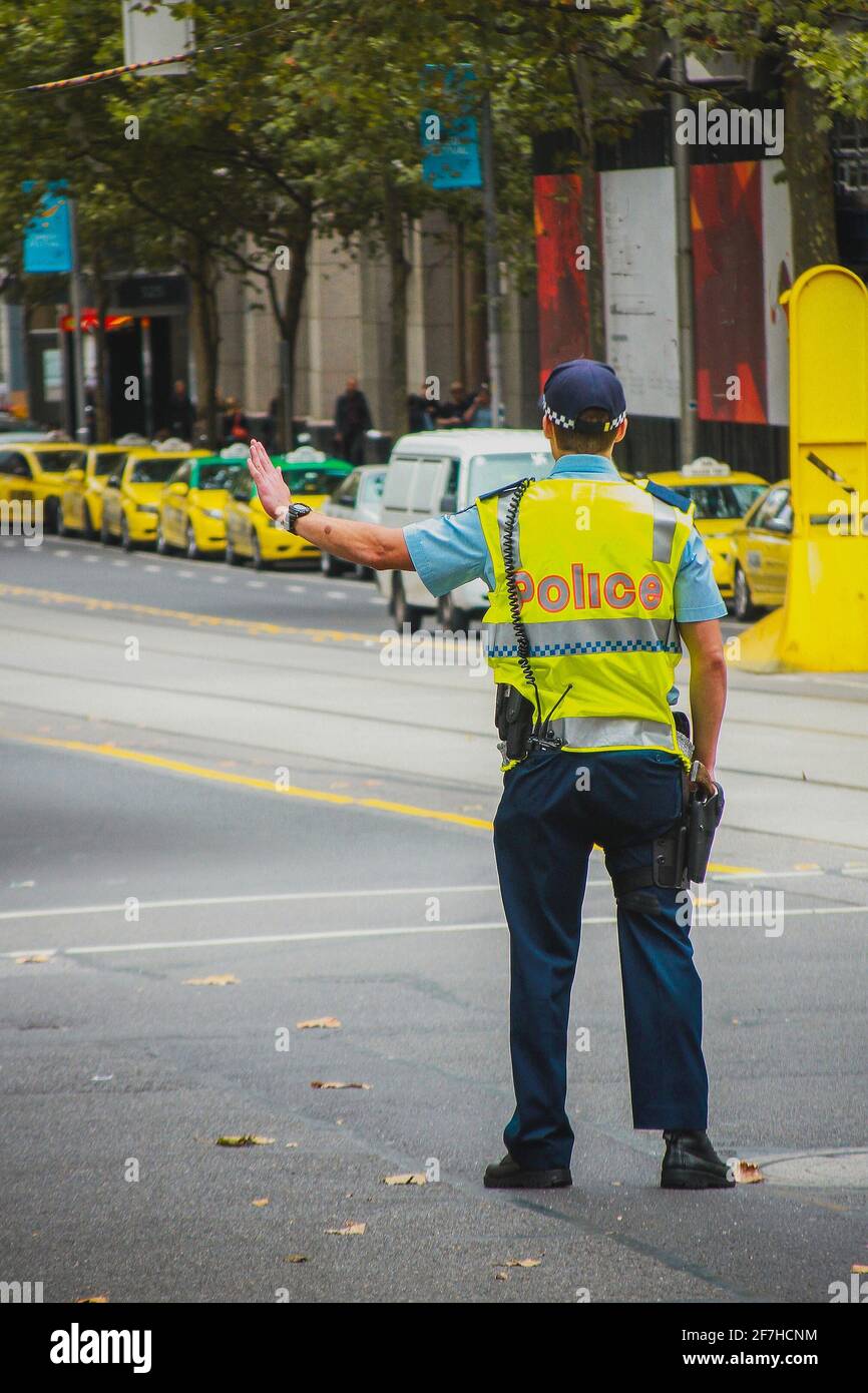 Policeman in australia, Melbourne is controlling traffic. Back view of ...