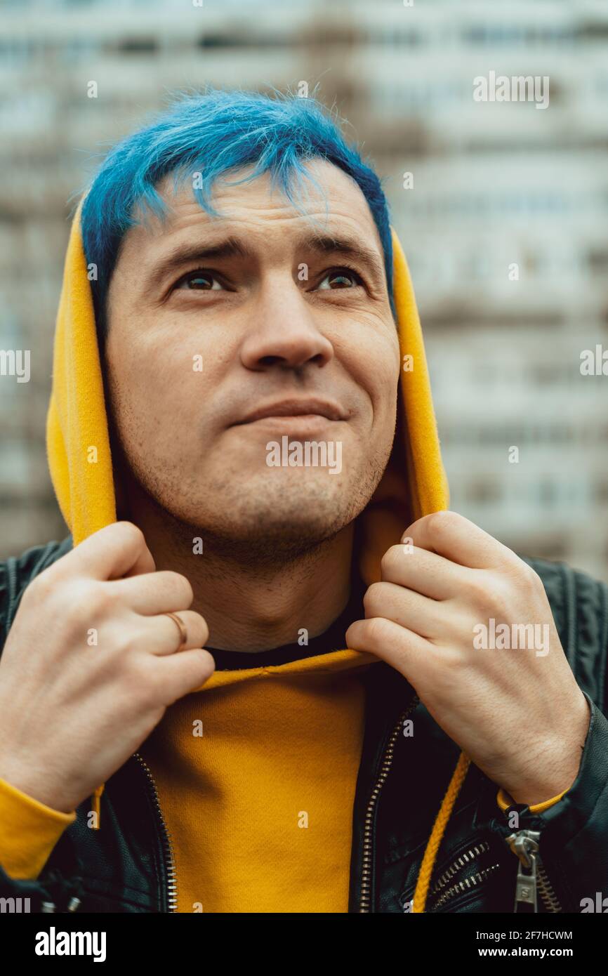 Portrait of young man in hood on background of high-rise building ...
