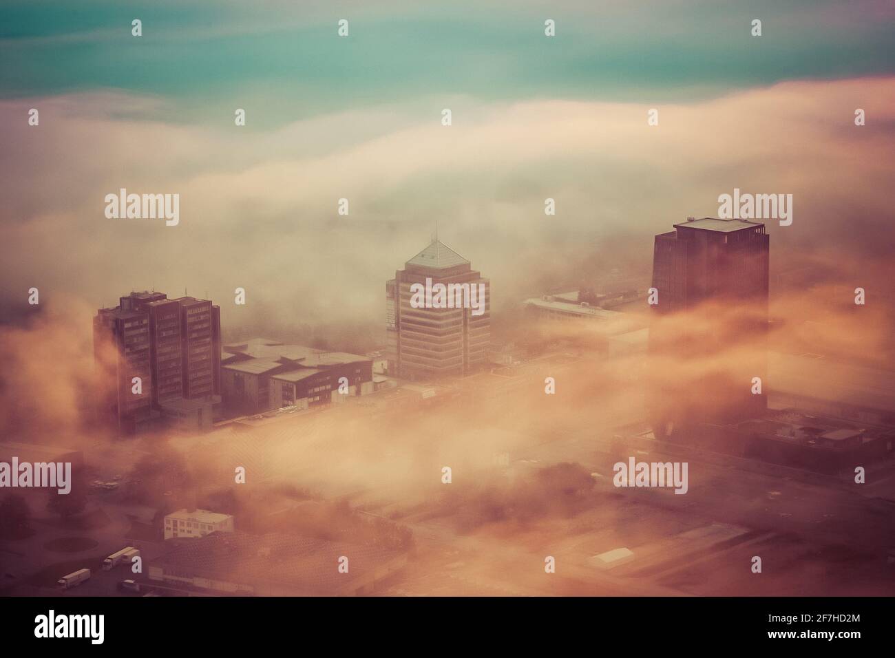 Three skyscrapers poking peeking rising out of the morning fog during ...