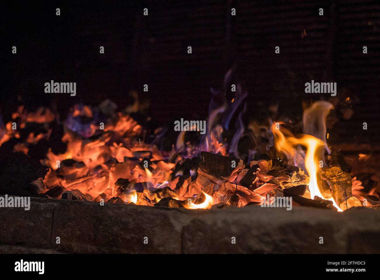 A big open fire grill being heated up with the aid of charcoal burning ...