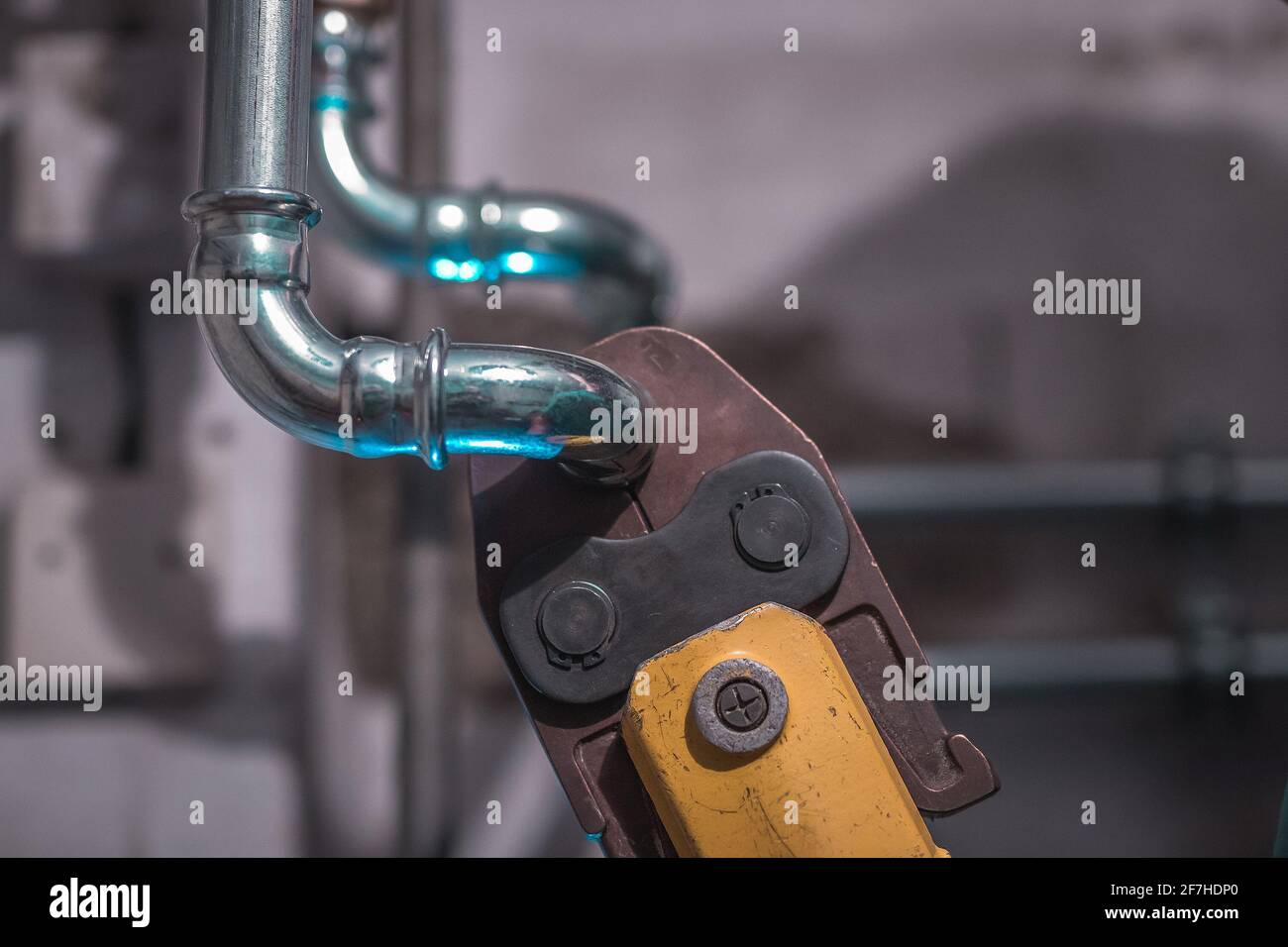 Plumber using pipe fastener or battery press tool to crimp heating or ...