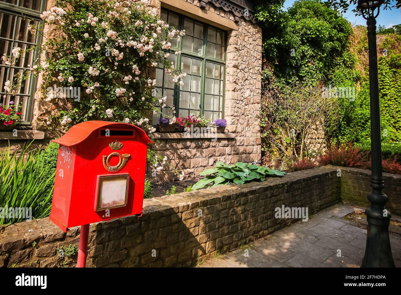 Red square mailbox in Belgium, in front of a typical house and some ...