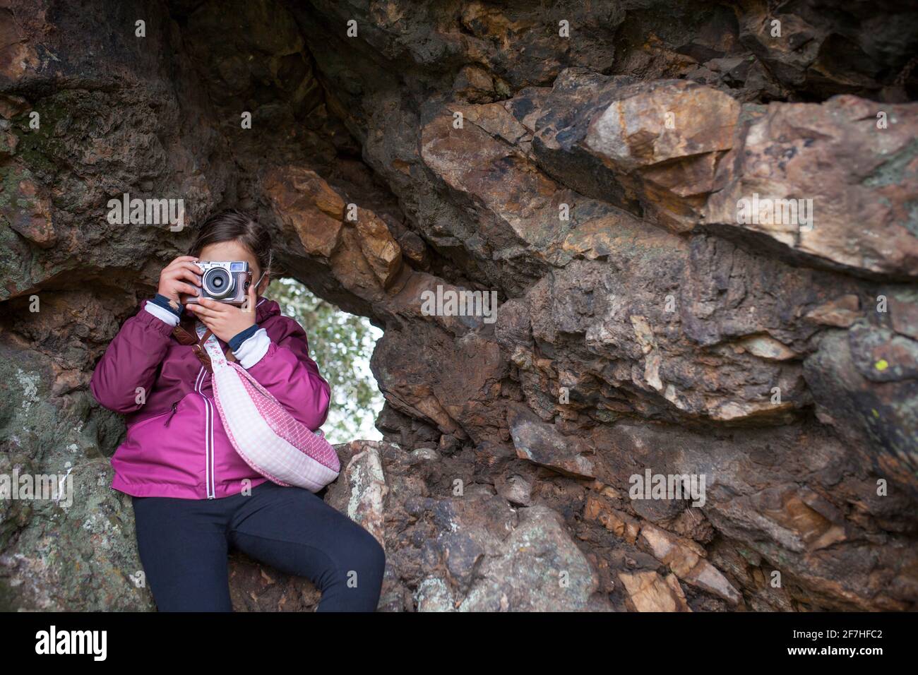 Child girl taking pictures from rock shelter. Children discover nature ...