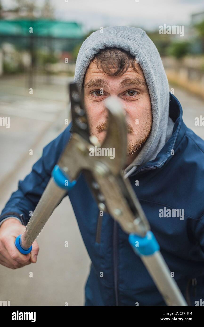 Crazy deranged man with long pruning scissors in his hands attacking ...