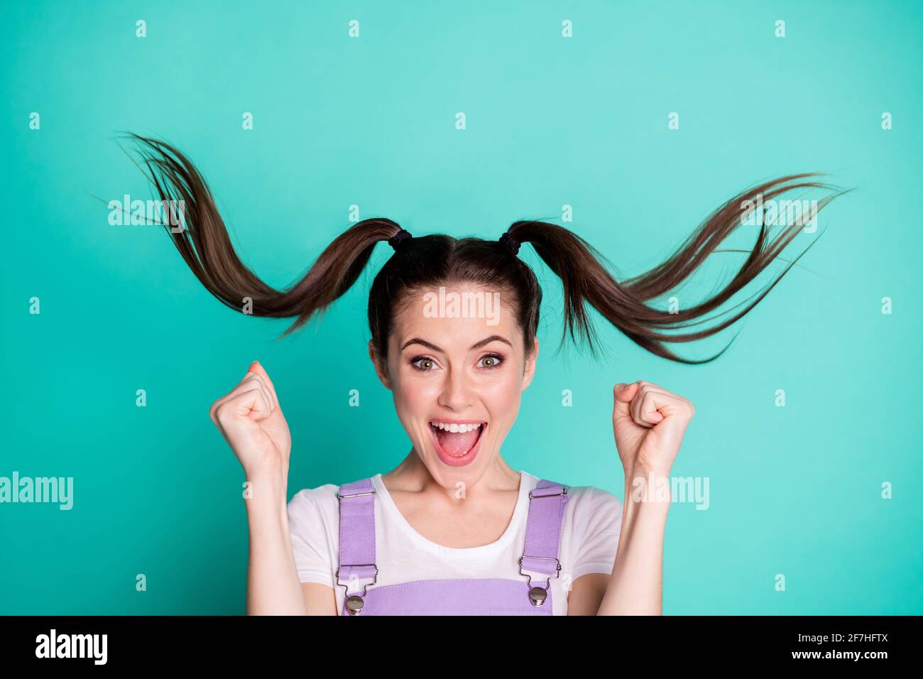 Photo of amazed crazy girl hold fists open mouth wear violet overall ...