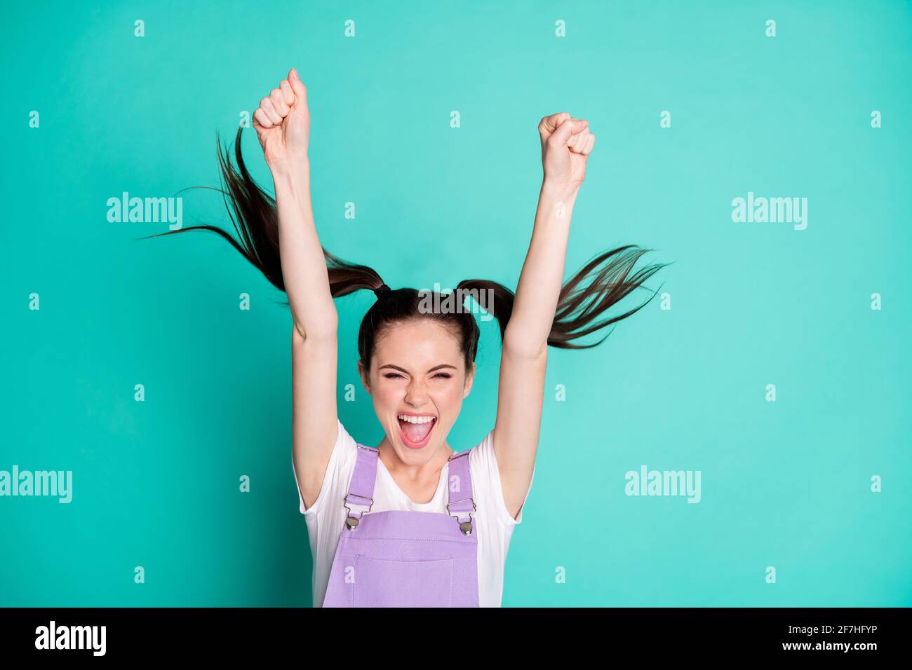 Photo of excited pretty lady raise hands open mouth wear violet overall ...