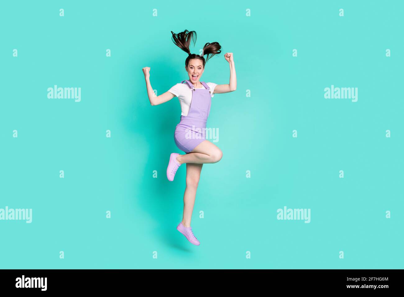 Full length photo of funny cheerful girl jump wind tails raise knee ...