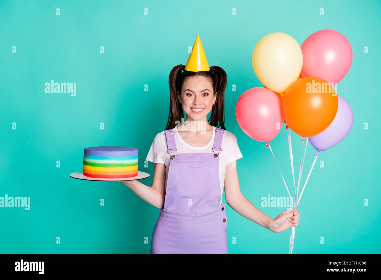 Photo of pretty young girl hold balloons rainbow cake wear violet ...