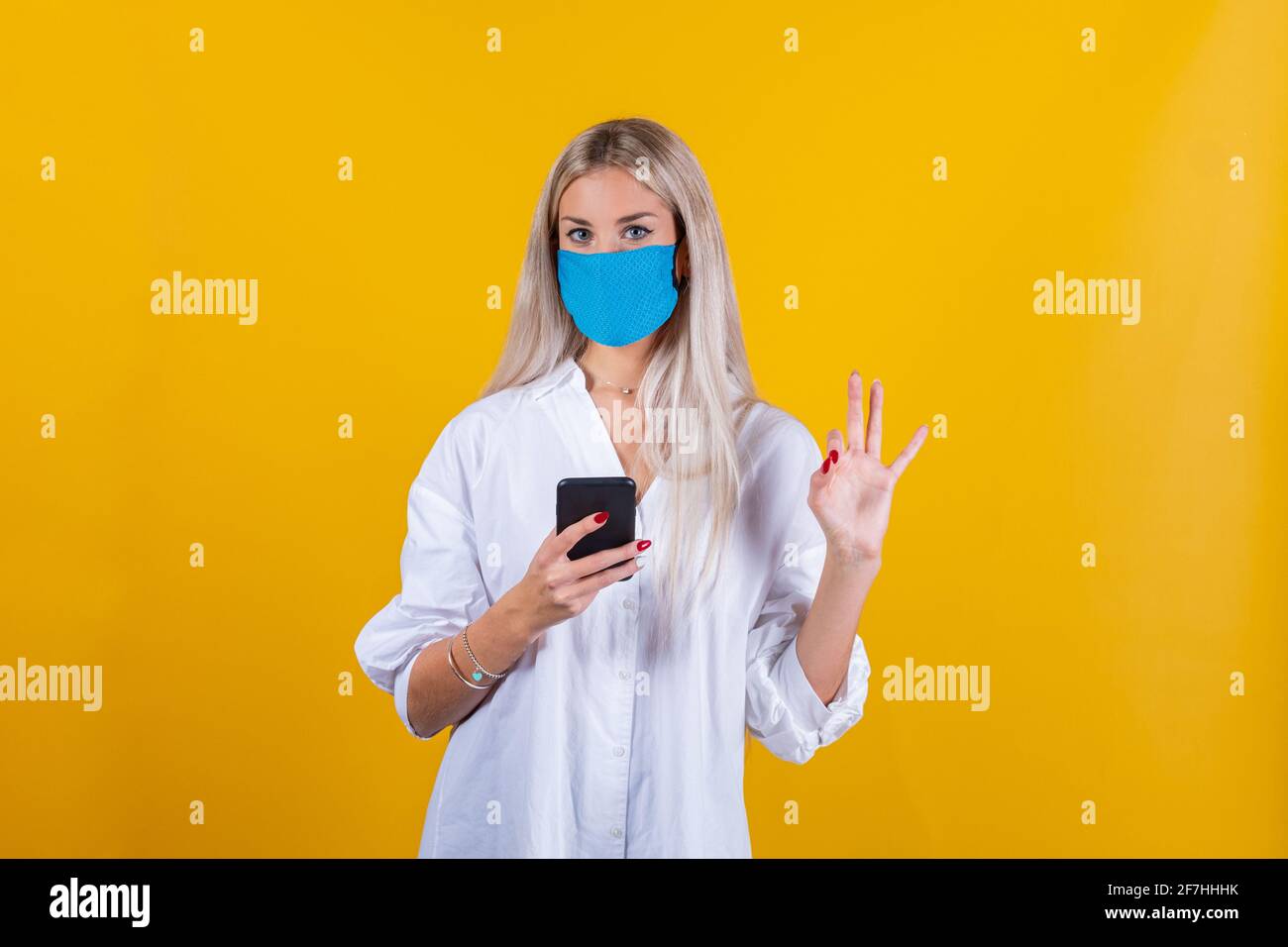 Woman wearing face mask protect from virus showing ok sign. Young girl ...