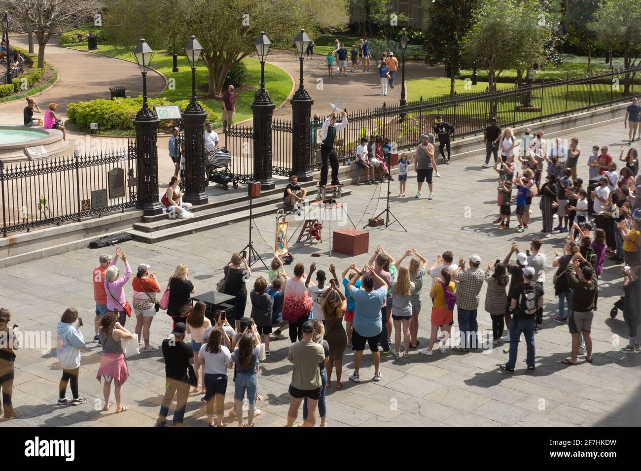 Spectators watch a performer next to Jackson Square in the New Orleans ...