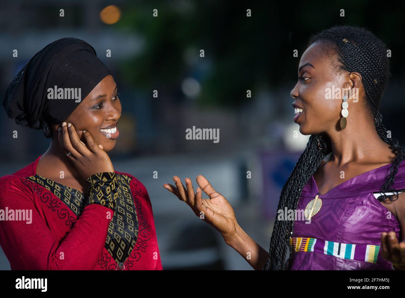 young african women standing outdoors talking to each other while ...