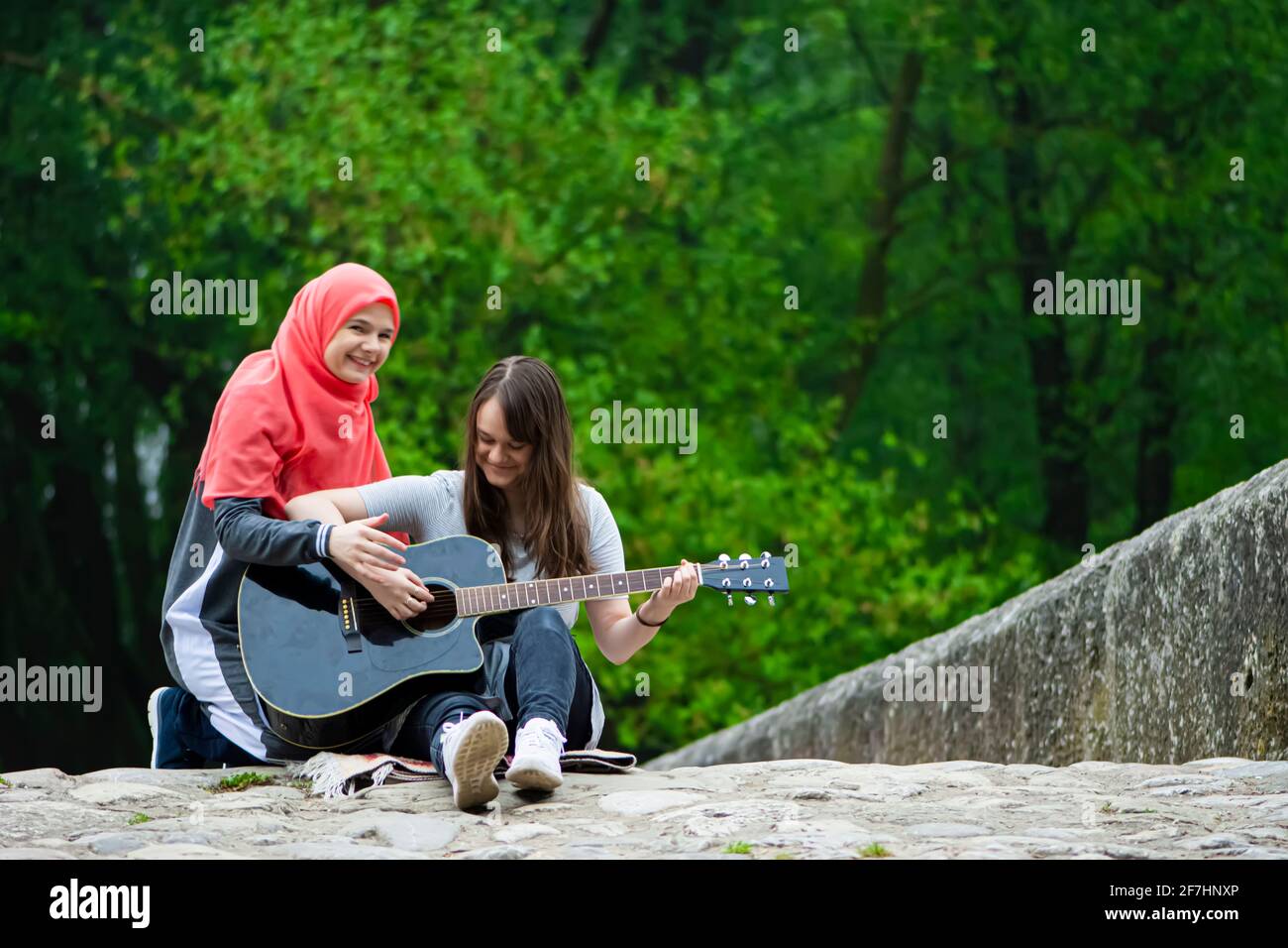 Two young muslim girls having guitar class Stock Photo - Alamy