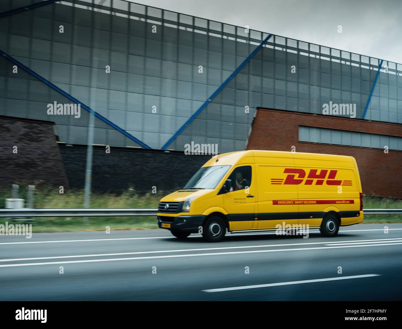 Side view of fast driving DHS fast delivery Volkswagen van on the Dutch ...