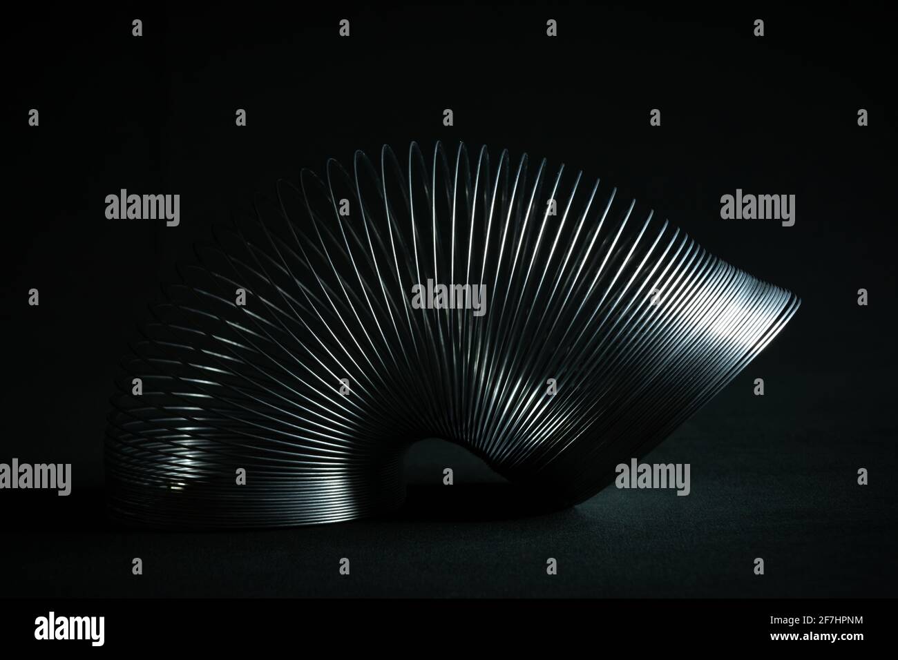Metal spring toy with black background Stock Photo - Alamy