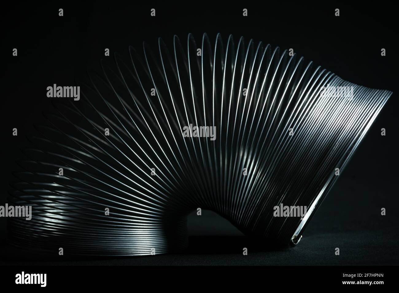 Metal spring toy with black background Stock Photo - Alamy