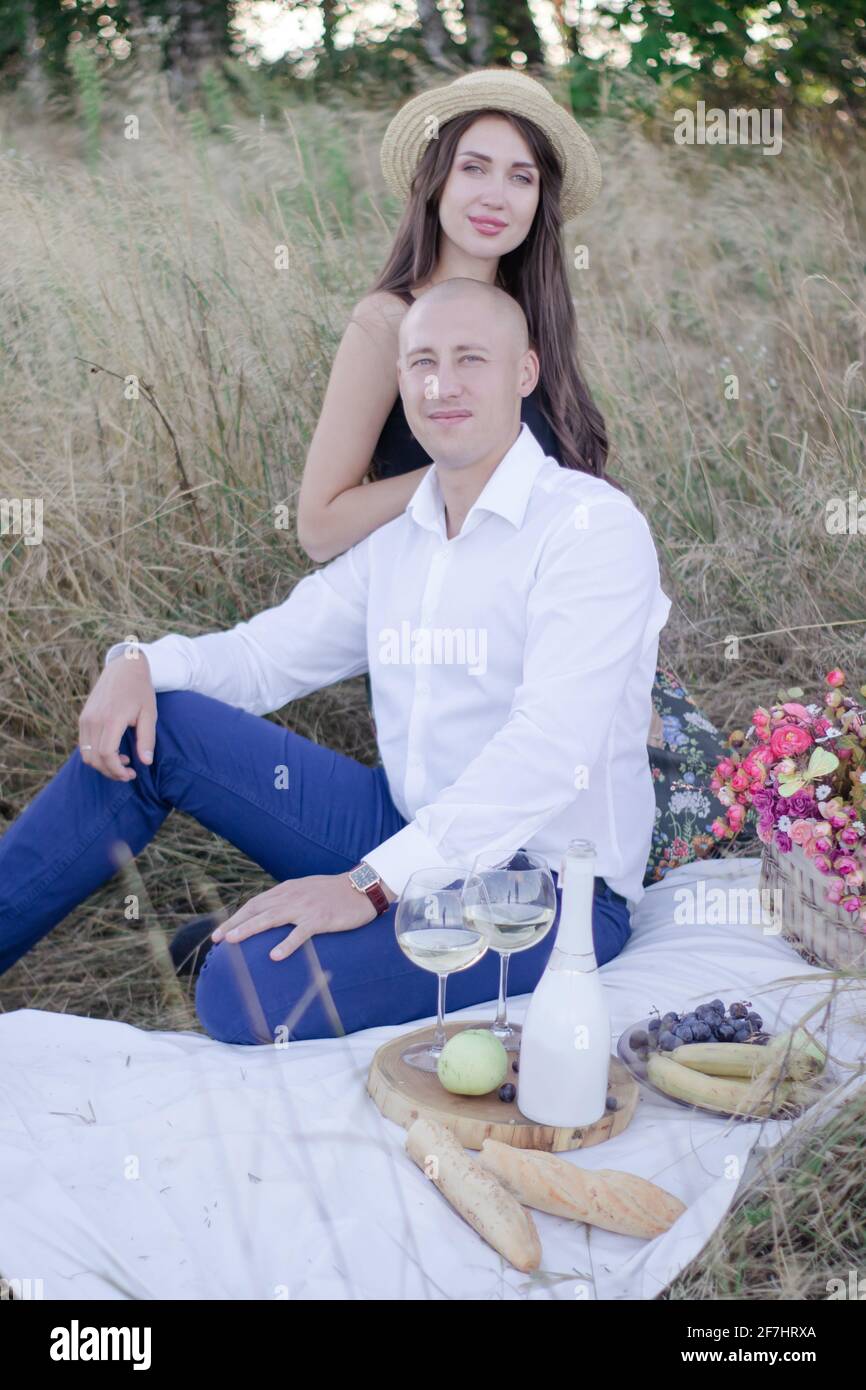 husband and wife on a romantic date on picnic sitting on a blanket with ...