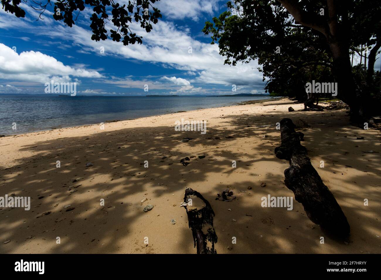Indonesian beach scene with yellow sand and calm seas Stock Photo - Alamy