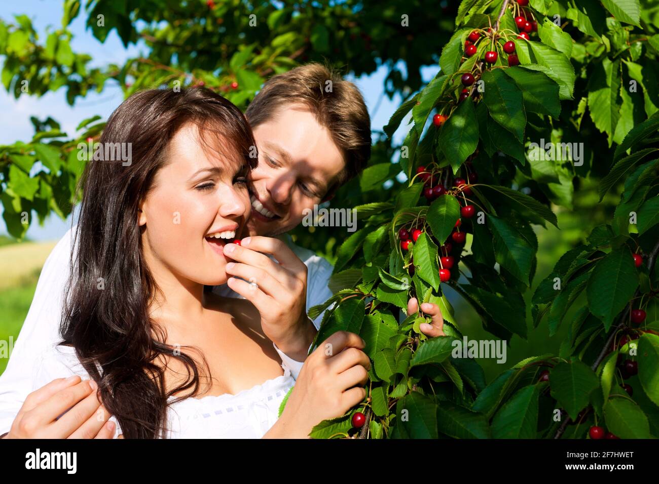 Young man eating cherries in hi-res stock photography and images - Alamy