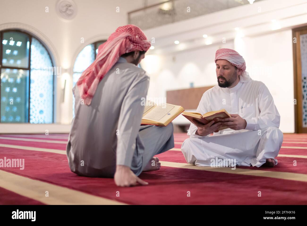 two muslim people in mosque reading quran together concept of islamic ...
