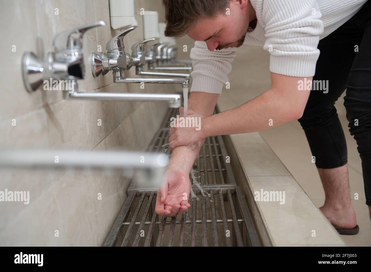 A Muslim takes ablution for prayer. Islamic religious rite Stock Photo ...