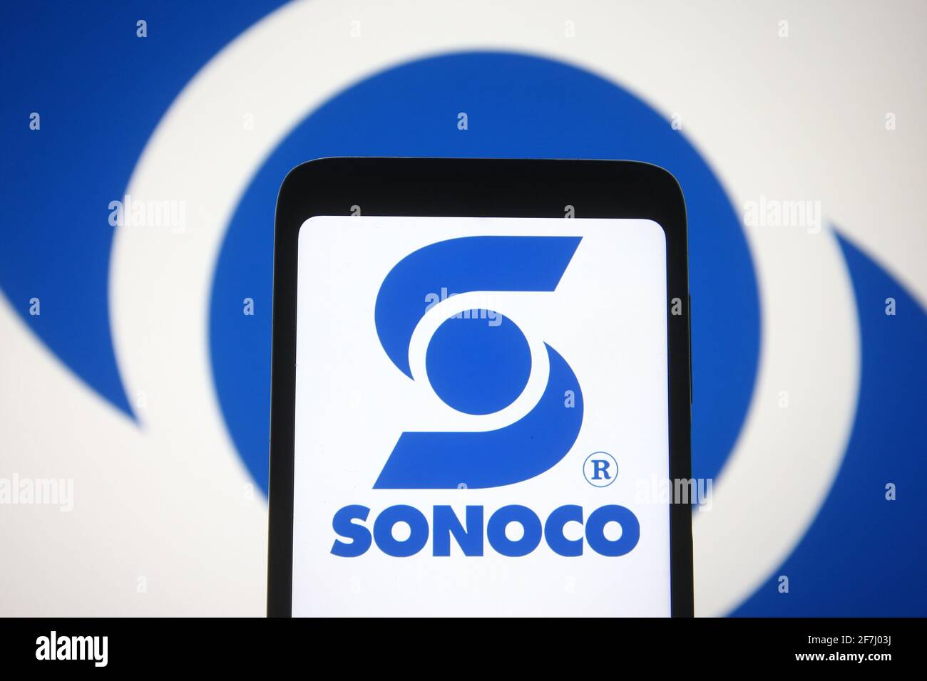 In this photo illustration the Sonoco logo is seen on a smartphone and a pc screen Stock Photo ...