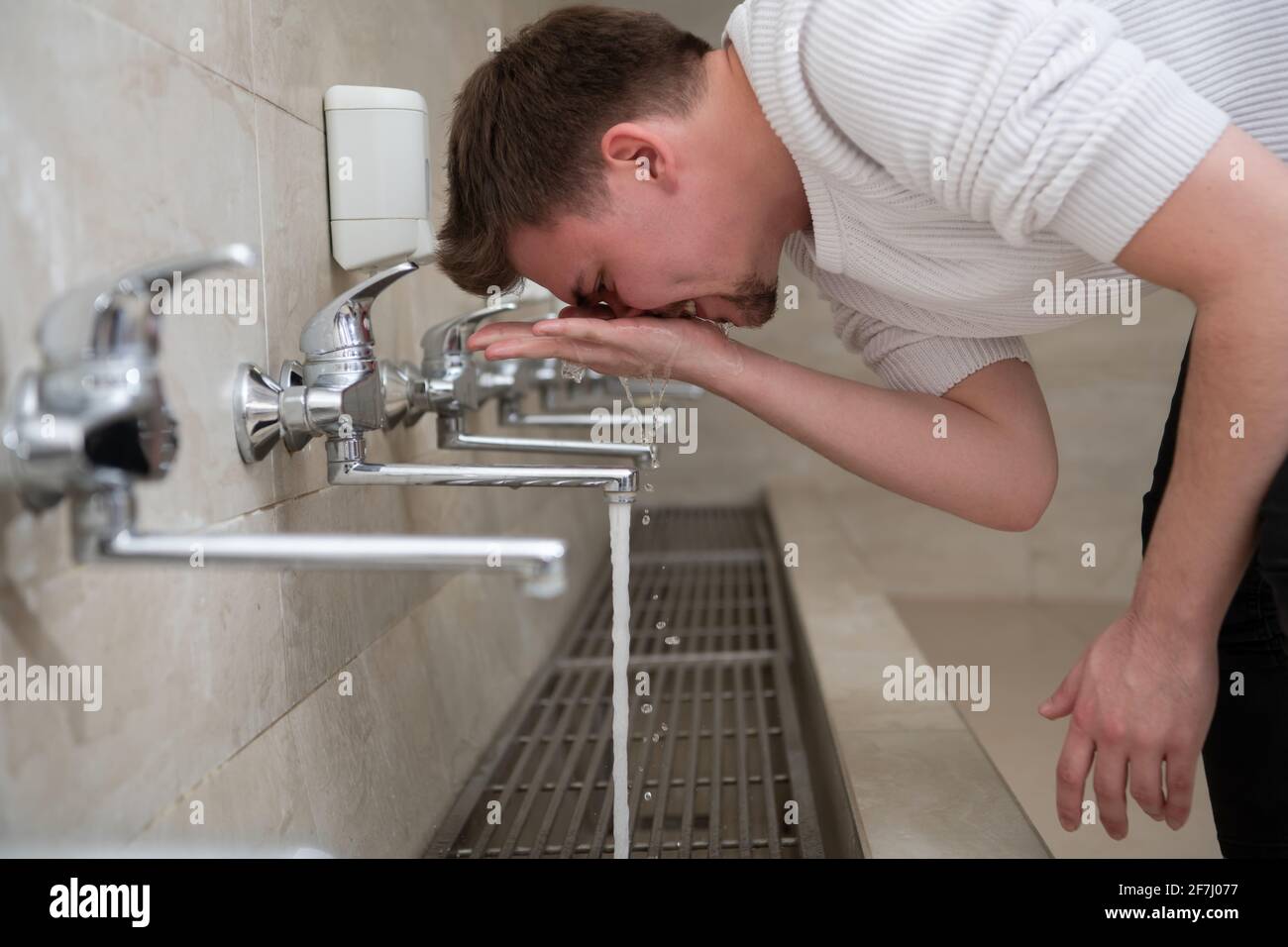 A Muslim takes ablution for prayer. Islamic religious rite Stock Photo ...