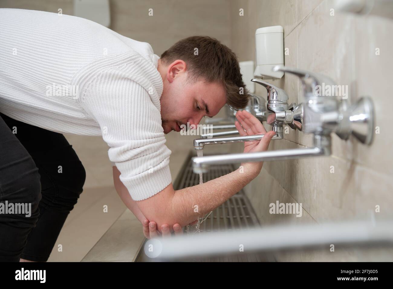 A Muslim takes ablution for prayer. Islamic religious rite Stock Photo ...