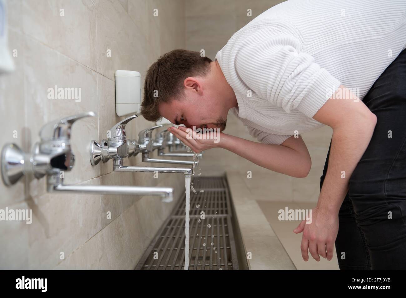 A Muslim takes ablution for prayer. Islamic religious rite Stock Photo ...