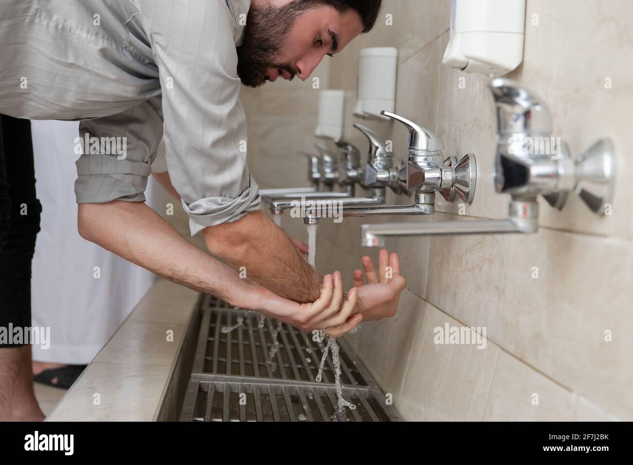a group of Muslims take ablution for prayer. Islamic religious rite ...