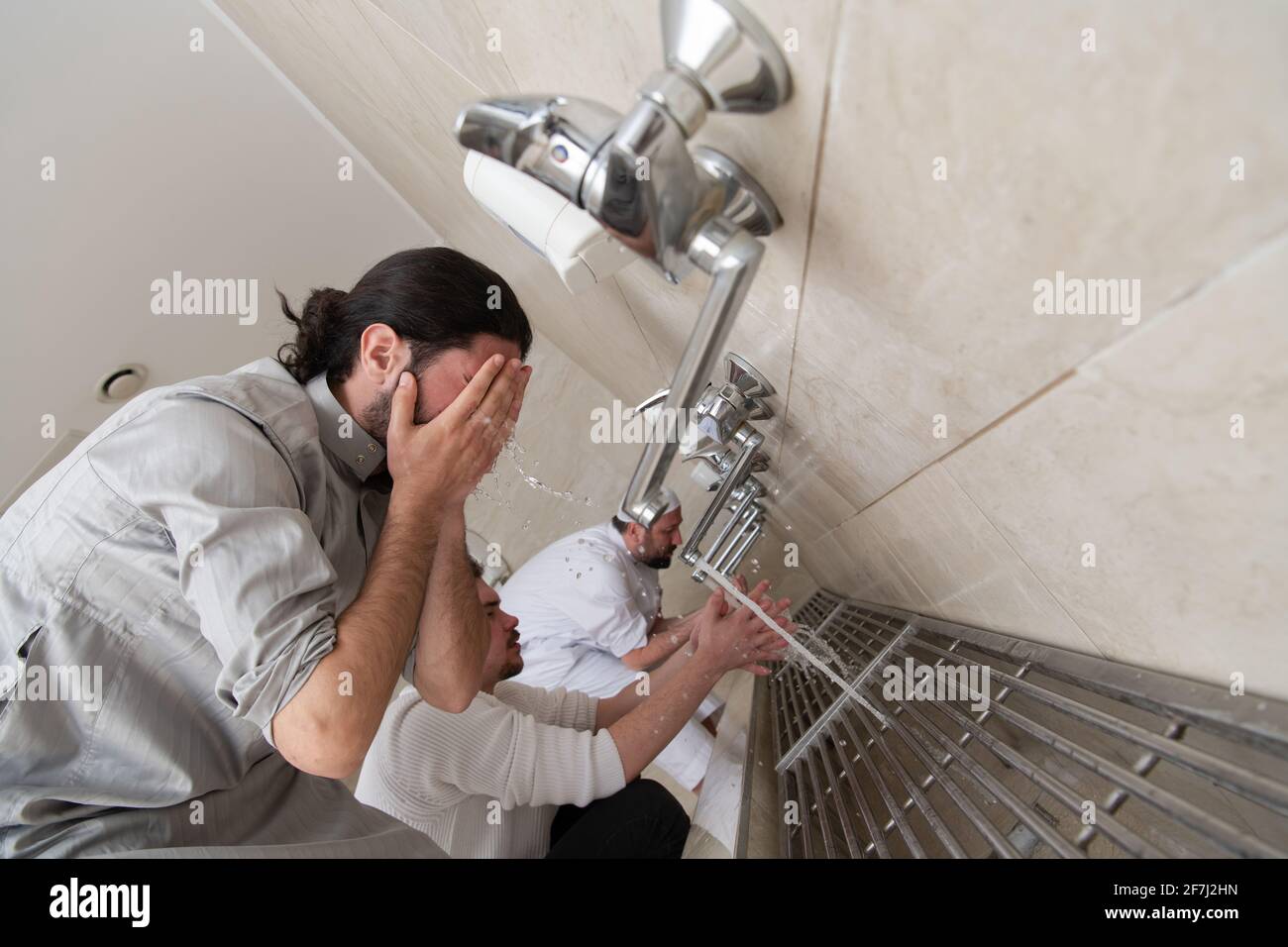a group of Muslims take ablution for prayer. Islamic religious rite ...