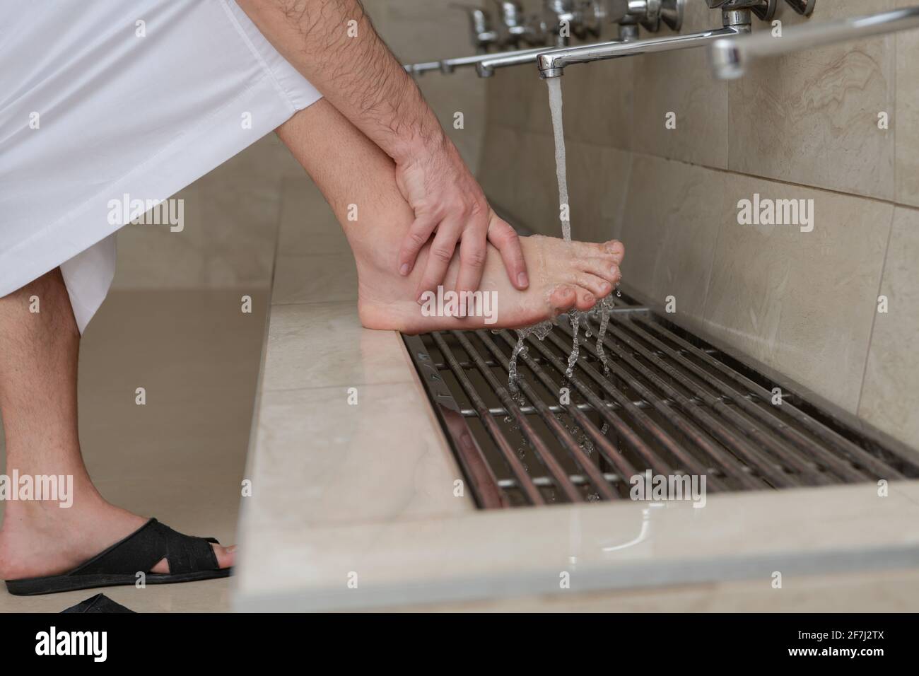 A Muslim takes ablution for prayer. Islamic religious rite Stock Photo ...