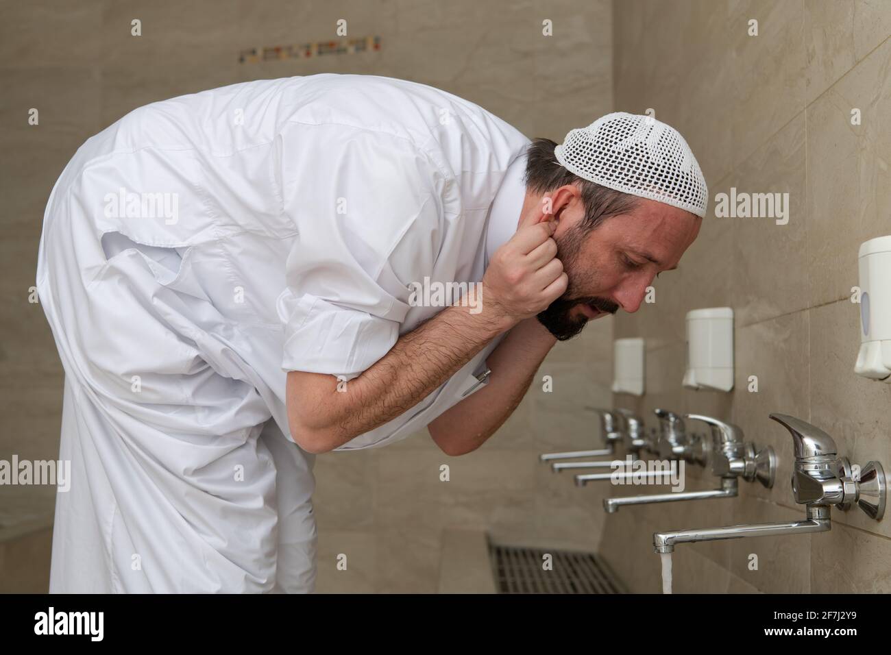 A Muslim takes ablution for prayer. Islamic religious rite Stock Photo ...