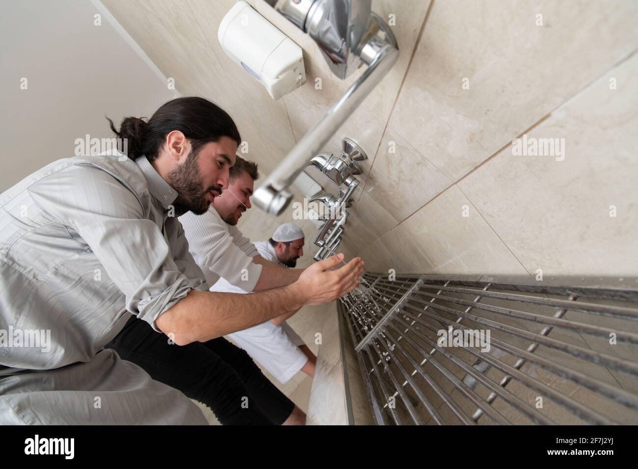a group of Muslims take ablution for prayer. Islamic religious rite ...