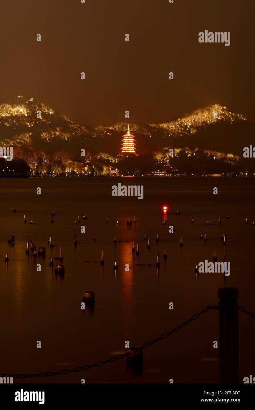 Leifeng Tower with lights on during night time with reflection on West ...