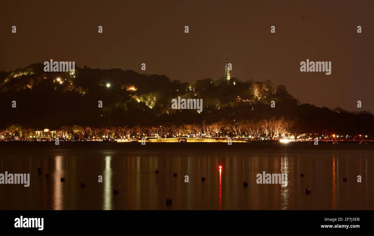 Leifeng Tower with lights on during night time with reflection on West ...