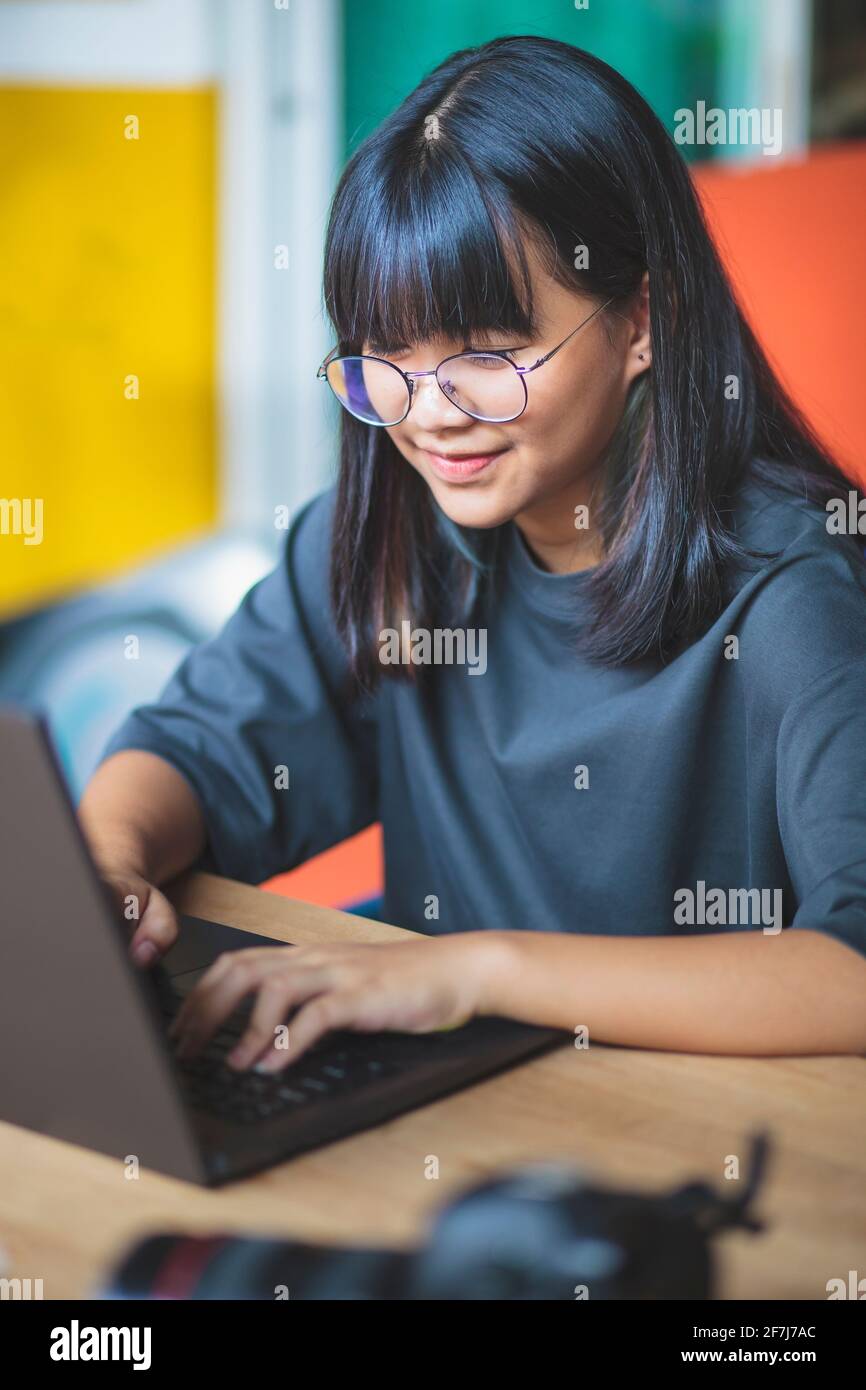 asian teenager working on computer laptop in living room Stock Photo ...