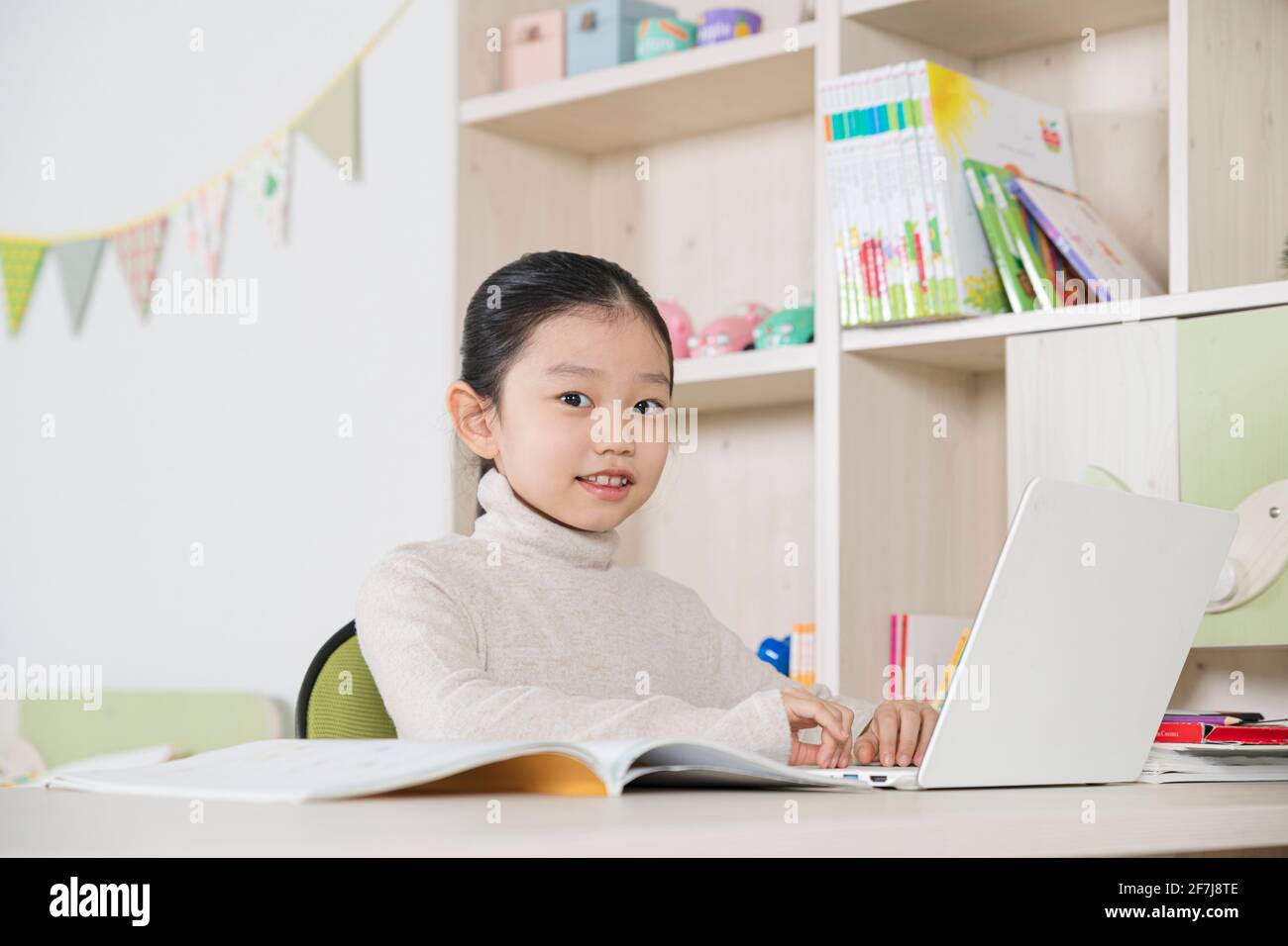 Asian girl studying on table using laptop device Stock Photo - Alamy