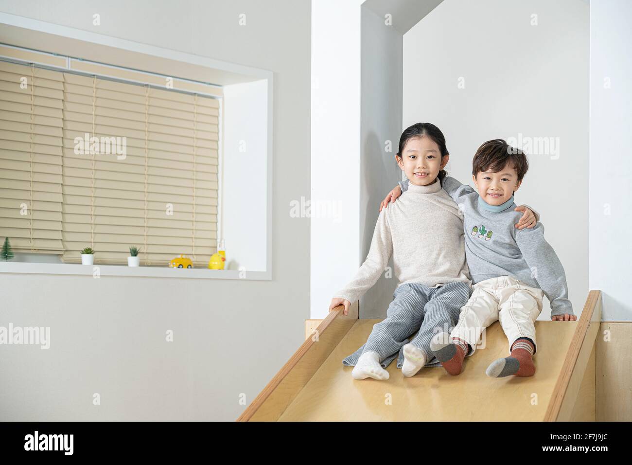 Asian siblings on the slide Stock Photo - Alamy
