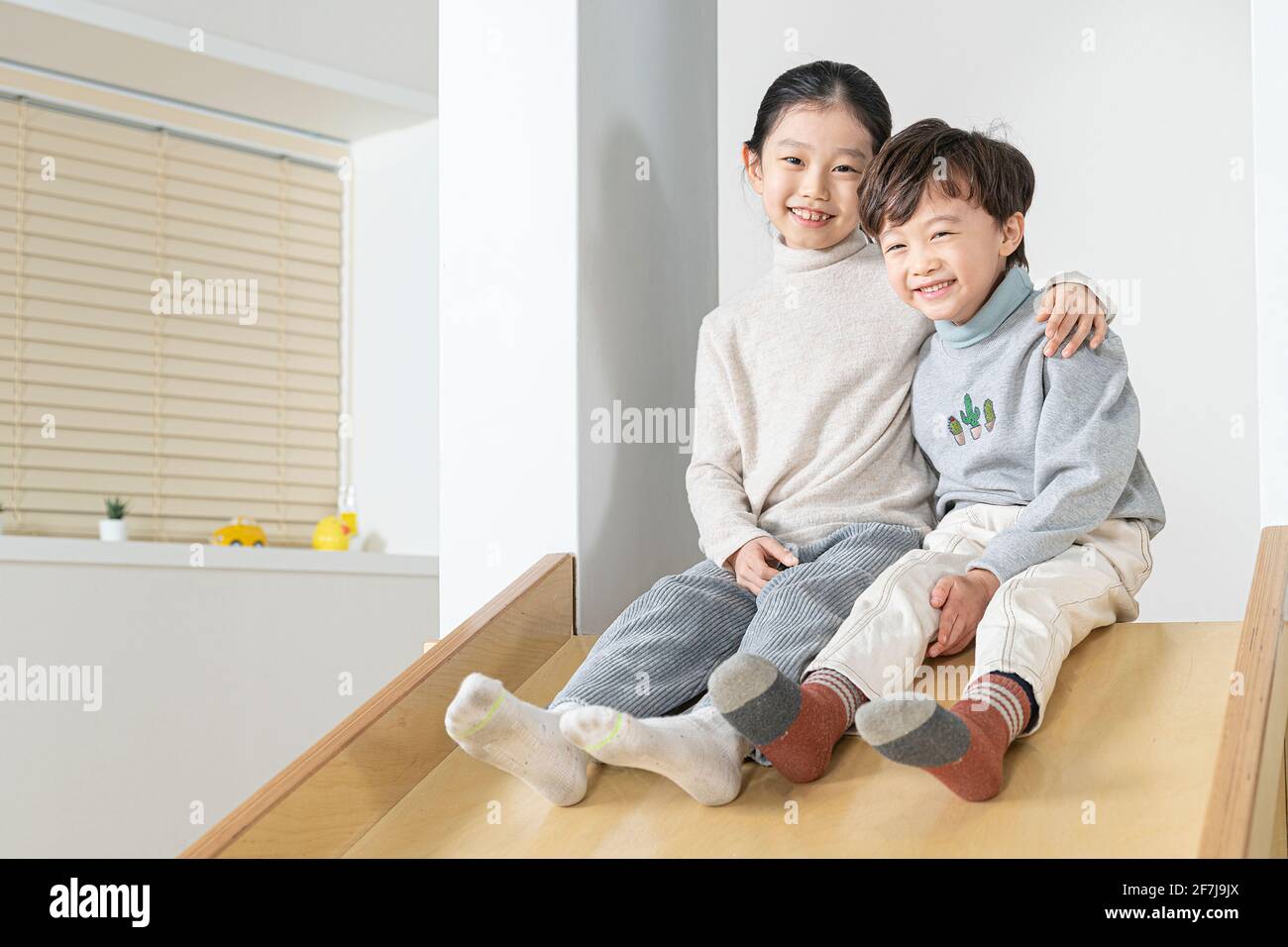 Asian siblings on the slide Stock Photo - Alamy