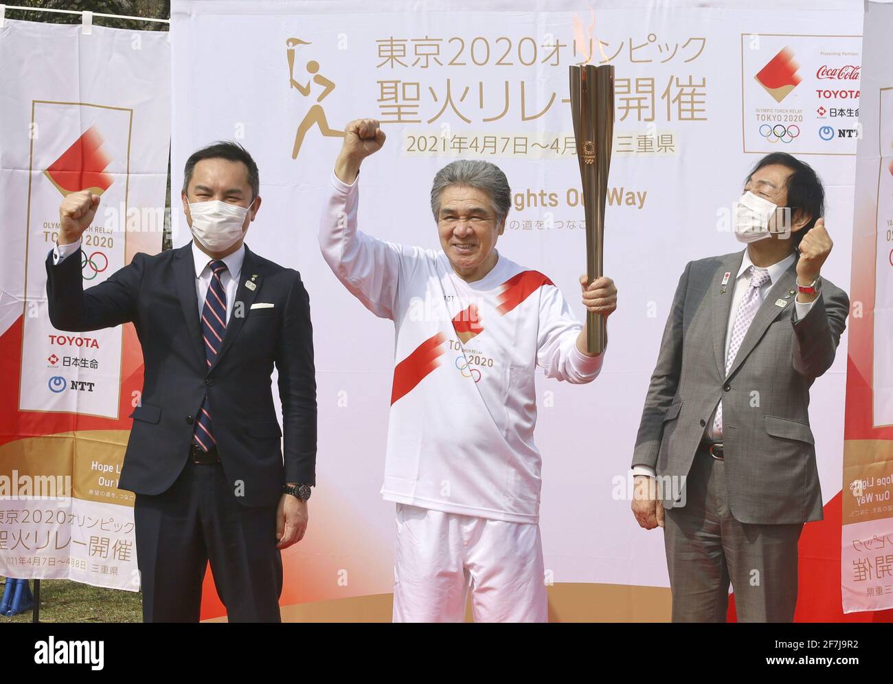 Veteran singer Ichiro Toba (C) poses with the Olympic flame in the Mie ...