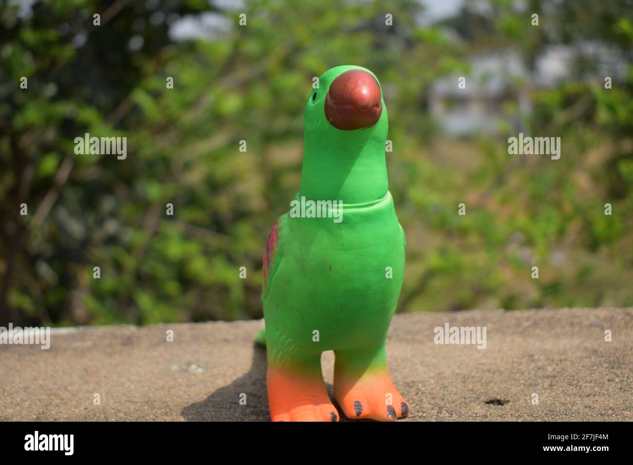 Green plastic parrot in the natural background. . natural background ...