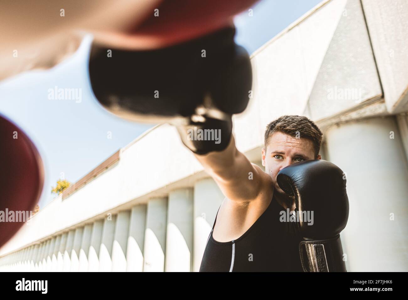 Two men exercising and fighting in outside. Boxer in gloves is training ...