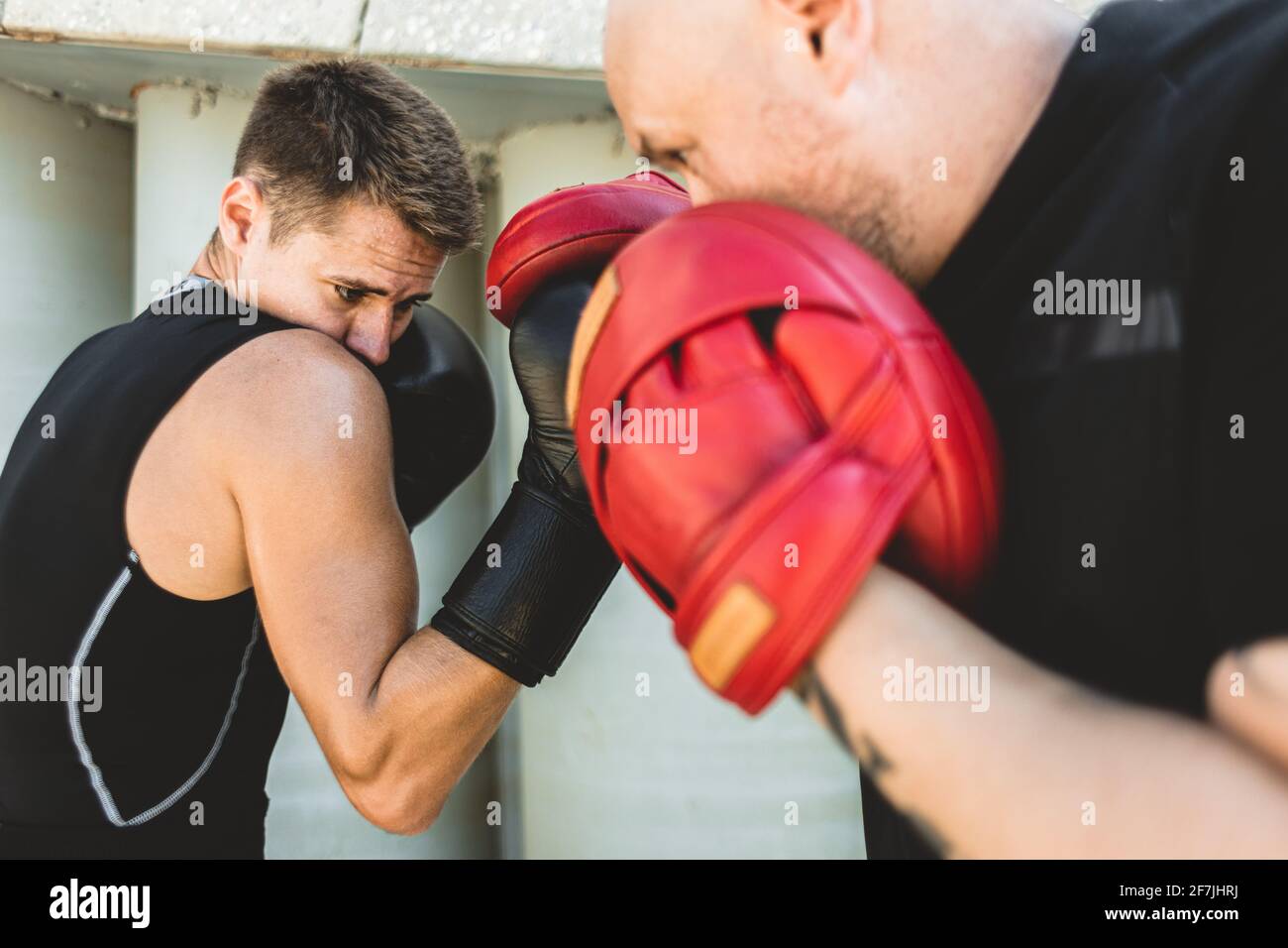 Two men exercising and fighting in outside. Boxer in gloves is training ...