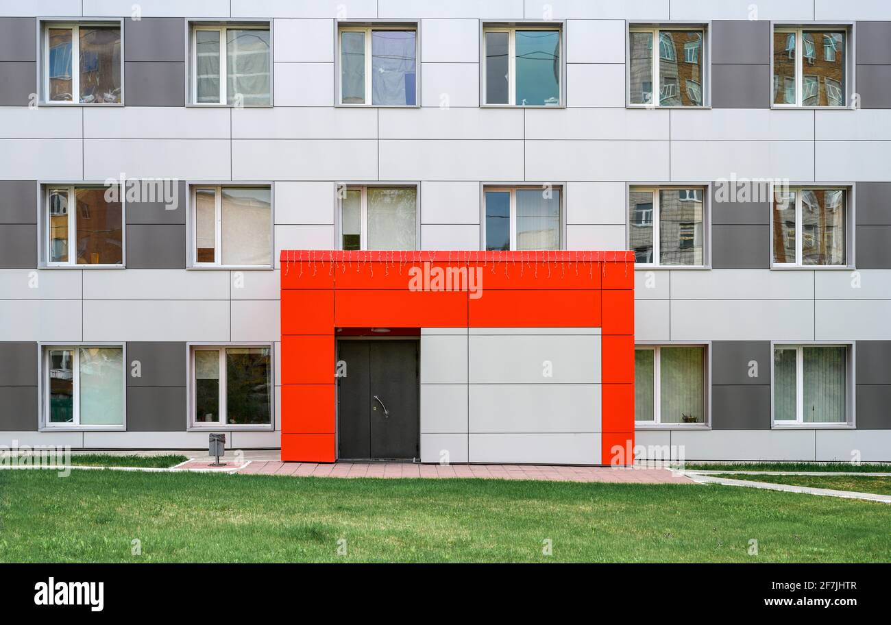 The wall of the building with a bright red entrance and bizarre ...