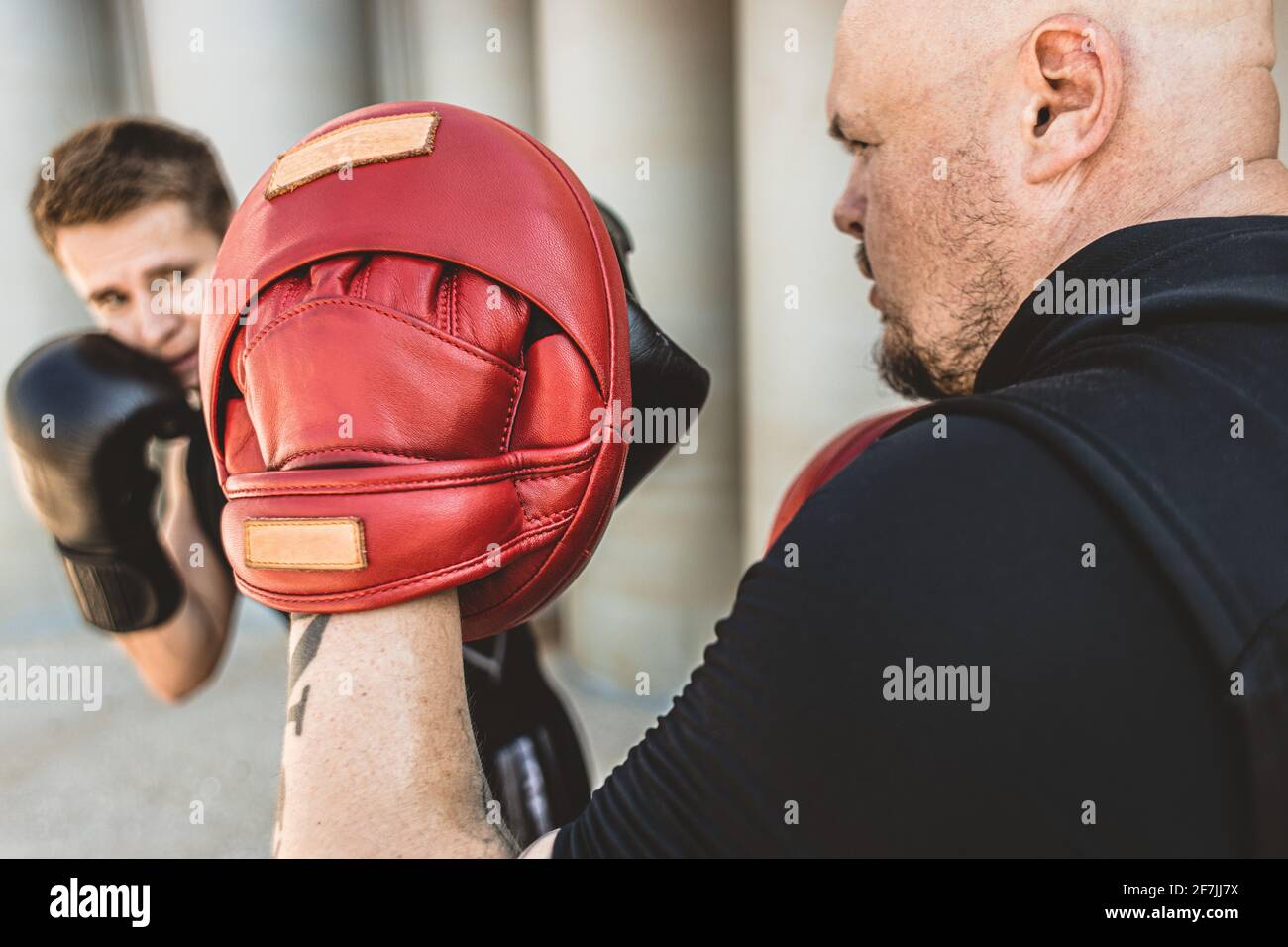 Two men exercising and fighting in outside. Boxer in gloves is training ...